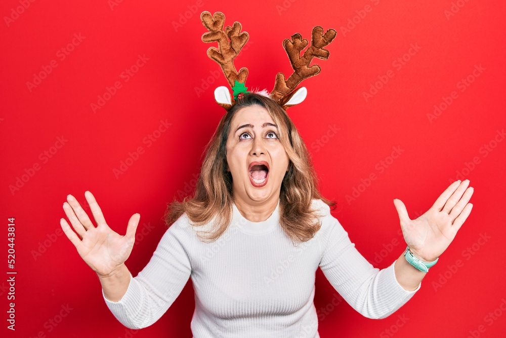 Middle age caucasian woman wearing cute christmas reindeer horns crazy ...