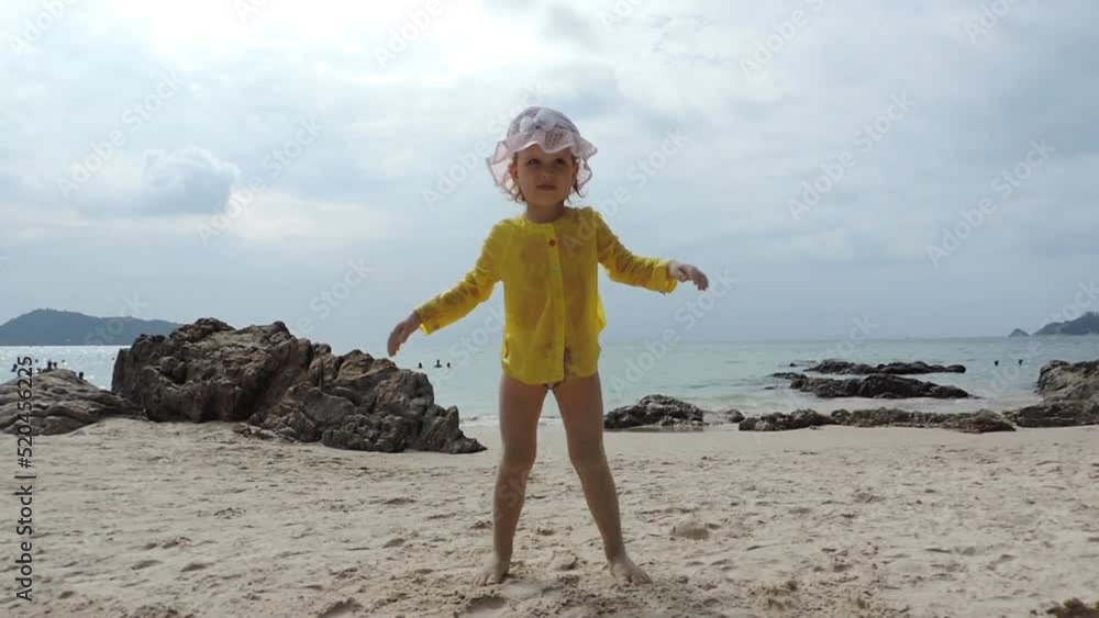 Happy cute girl playing on the beach, dancing, enjoying summer nature ...