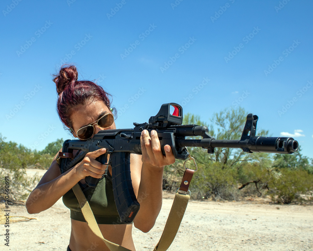 Latina girl holding tactical modified ak-47 assault rifle gun while ...