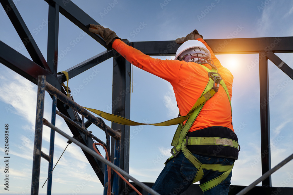 Stockfoto A Construction workers wear safety equipment to prevent falls ...