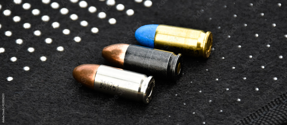 9mm pistol bullets and bullet shells on black leather background, soft ...