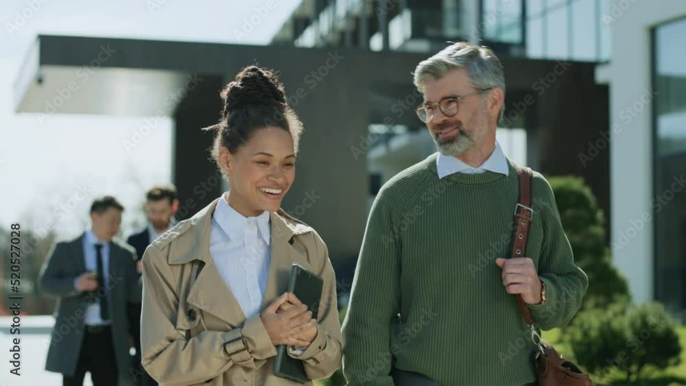 Outdoors two business people walking talking. Young woman have ...