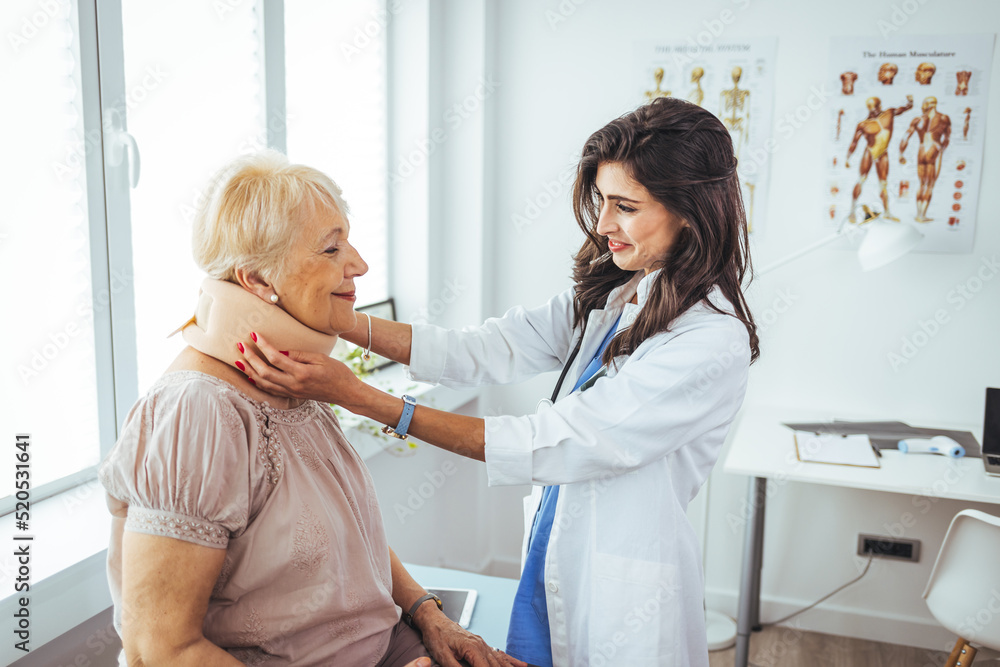 Female doctor putting neck orthopaedic collar on adult injured woman ...