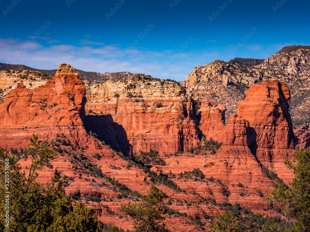 Gorgeous view of tall red rocks surrounded by dark green grass and ...