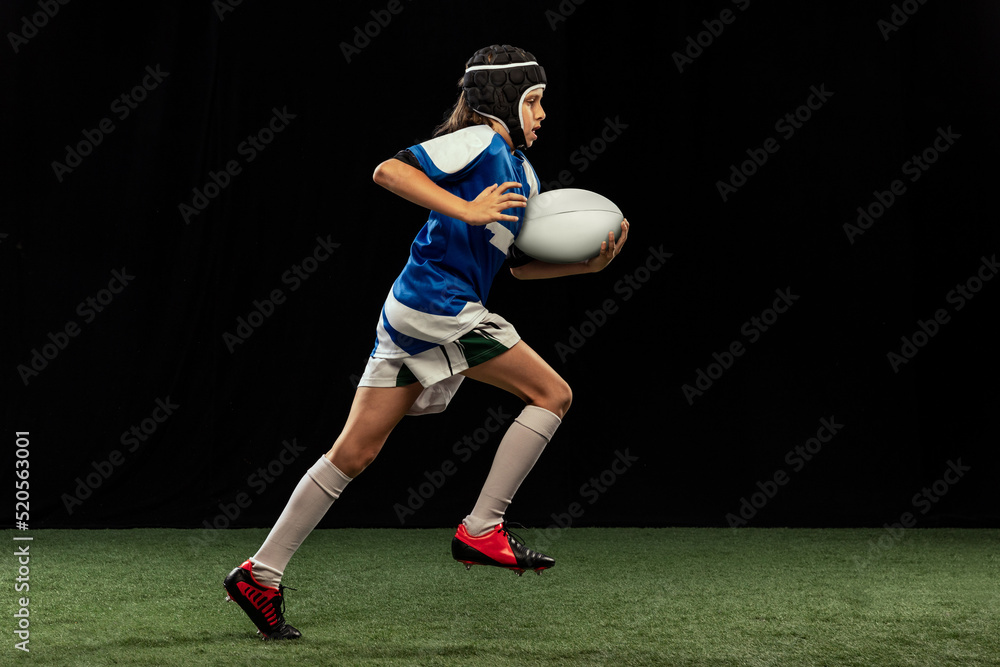 Dynamic portrait of school age boy, junior male rugby player practicing ...