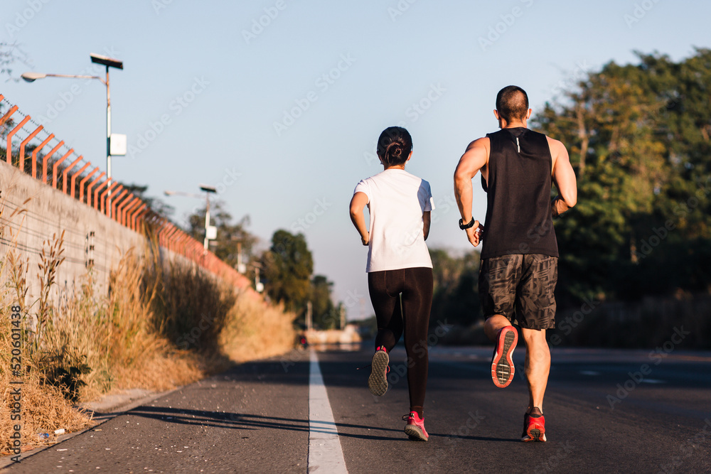 Runner wearing face mask while running together on the road from back ...