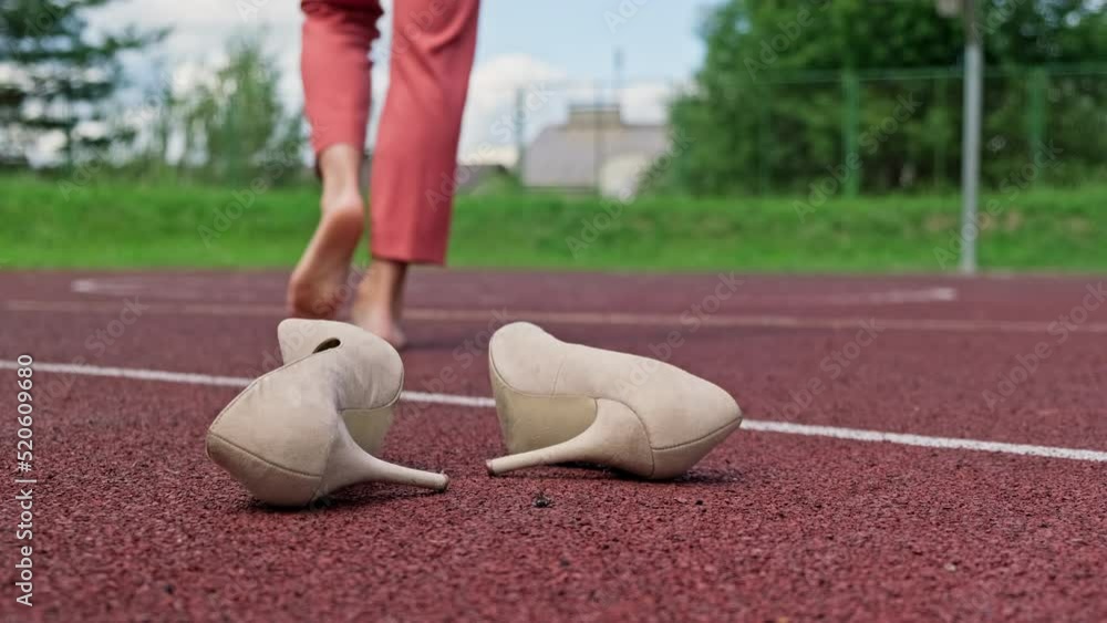 Successful young woman taking off shoes at basketball sports ground ...