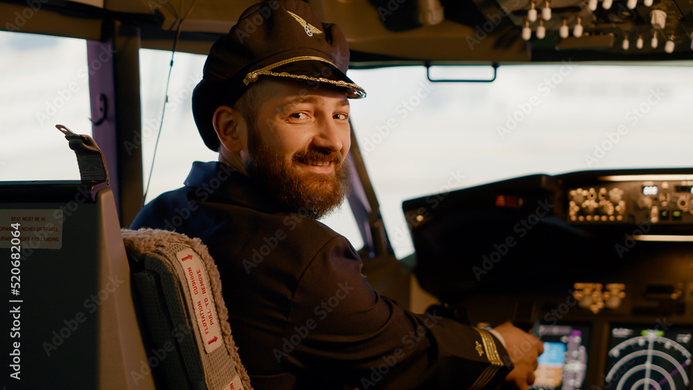 Portrait of airline captain sitting in pilot seat to fly airplane using ...