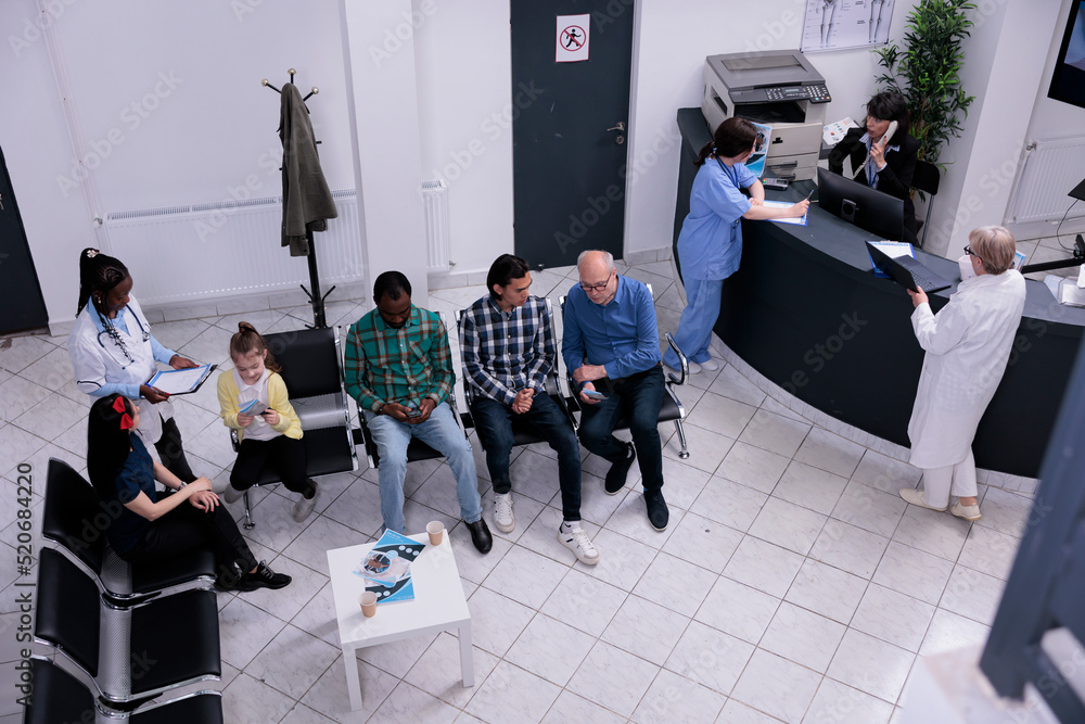 Top view of hospital waiting room with diverse group of people talking ...