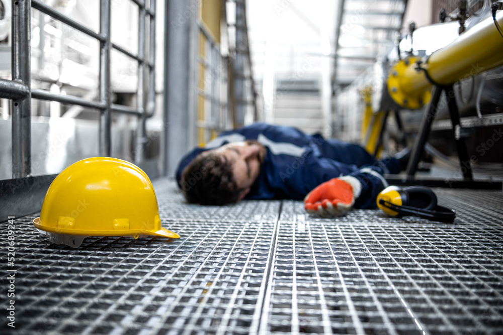 Blue collar worker lying down unconscious due to his injury at work and ...