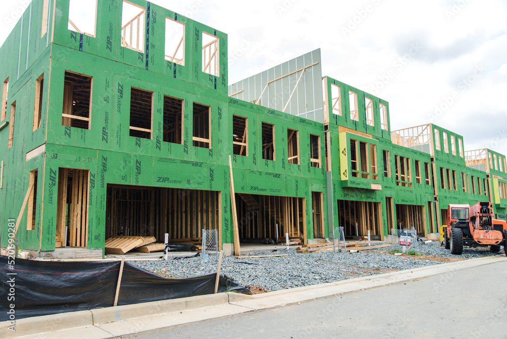 wooden frame of a three-story house sheathed with insulation panels ...
