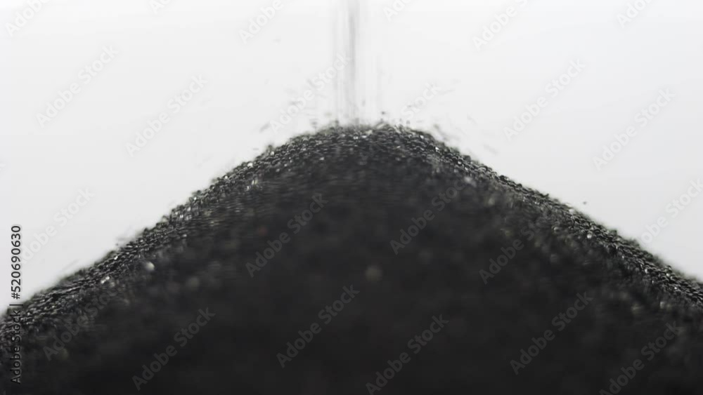 Grains of black sand and quartz are falling in a glass hourglass. Stock ...