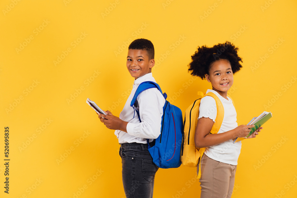Happy african american schoolgirl and mixed race schoolboy holding ...