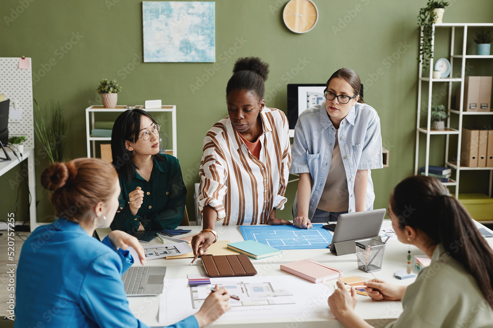 African architect presenting construction project to her colleagues at ...
