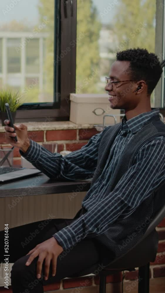 Vertical video: Business man using mobile phone to chat on remote video ...