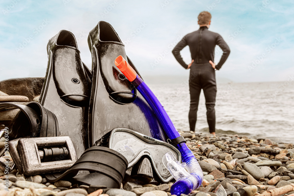 Flippers mask and cargo for scuba diving lie on the rocky seashore. In ...