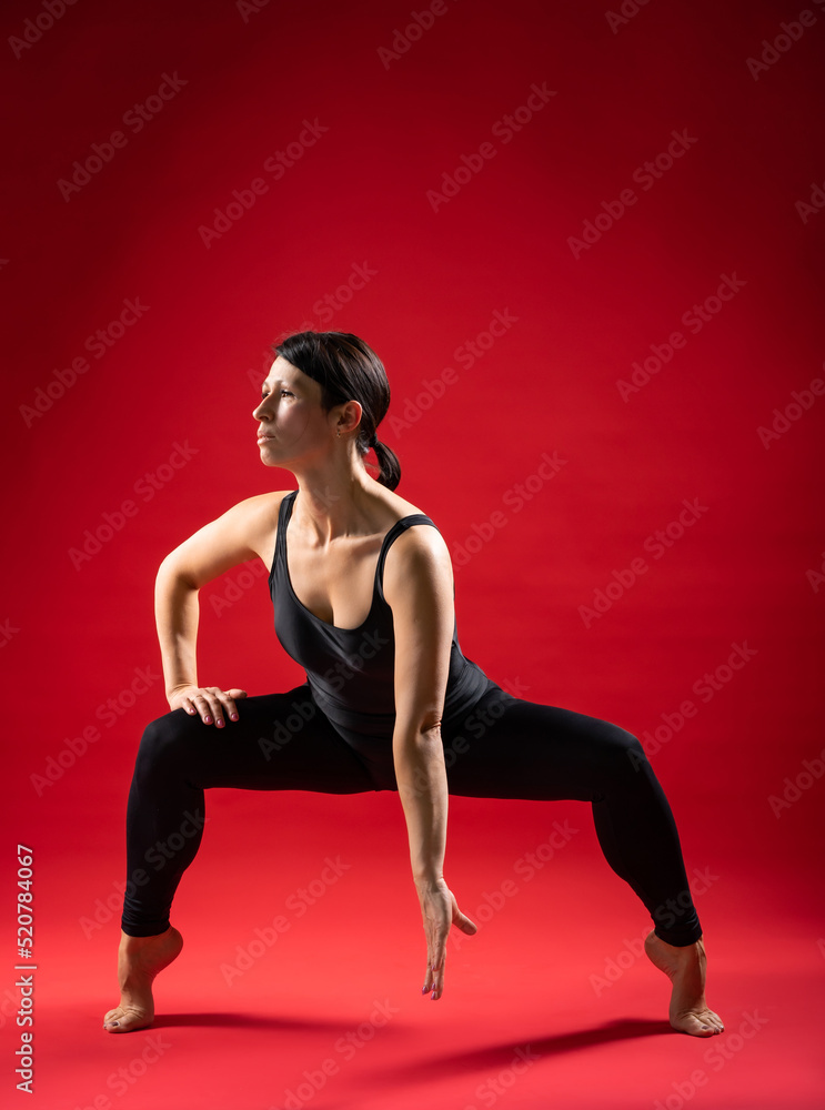 beautiful static poses. pilates on red background Woman in black ...
