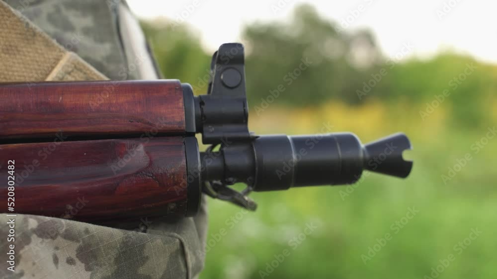 a Ukrainian soldier in camouflage holds a machine gun in a combat ...