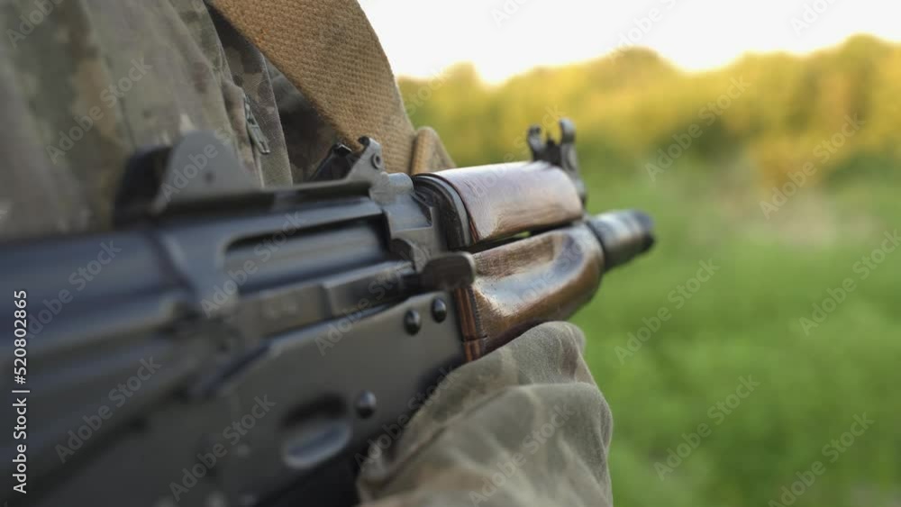 a Ukrainian soldier in camouflage holds a machine gun in a combat ...