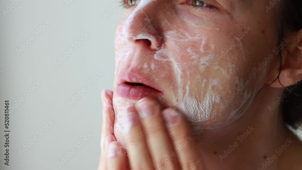 Cropped young woman washing cleaning face with organic foamy soap ...