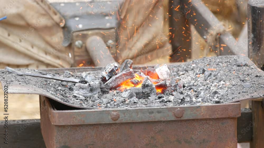 Medieval method of forging iron, the blacksmith forges an iron nail ...