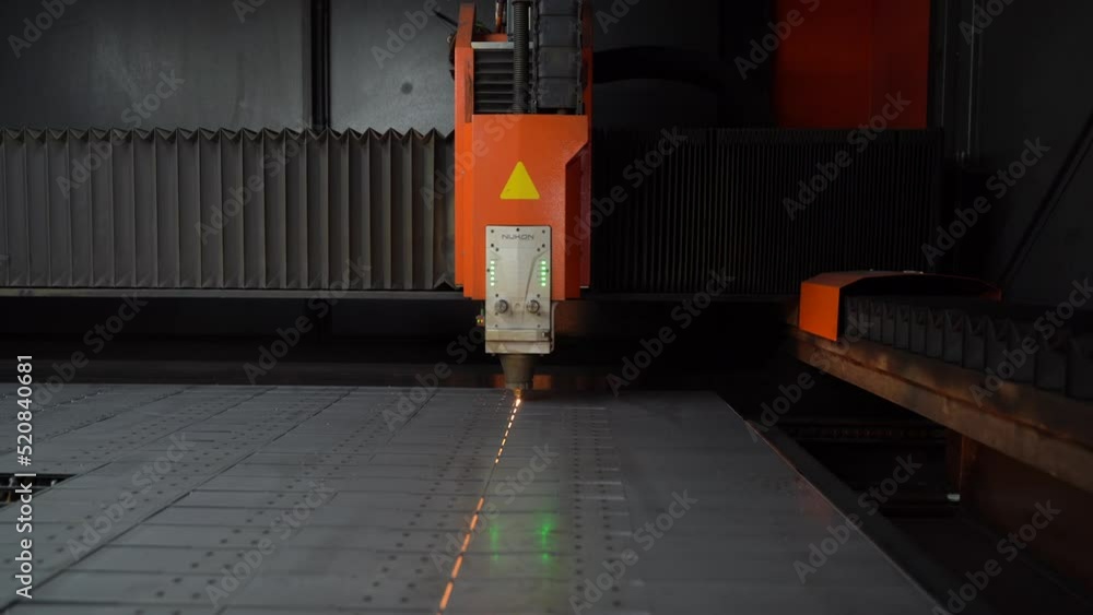 Industrial CNC laser cutting machine. A metal sheet is being cut on a ...