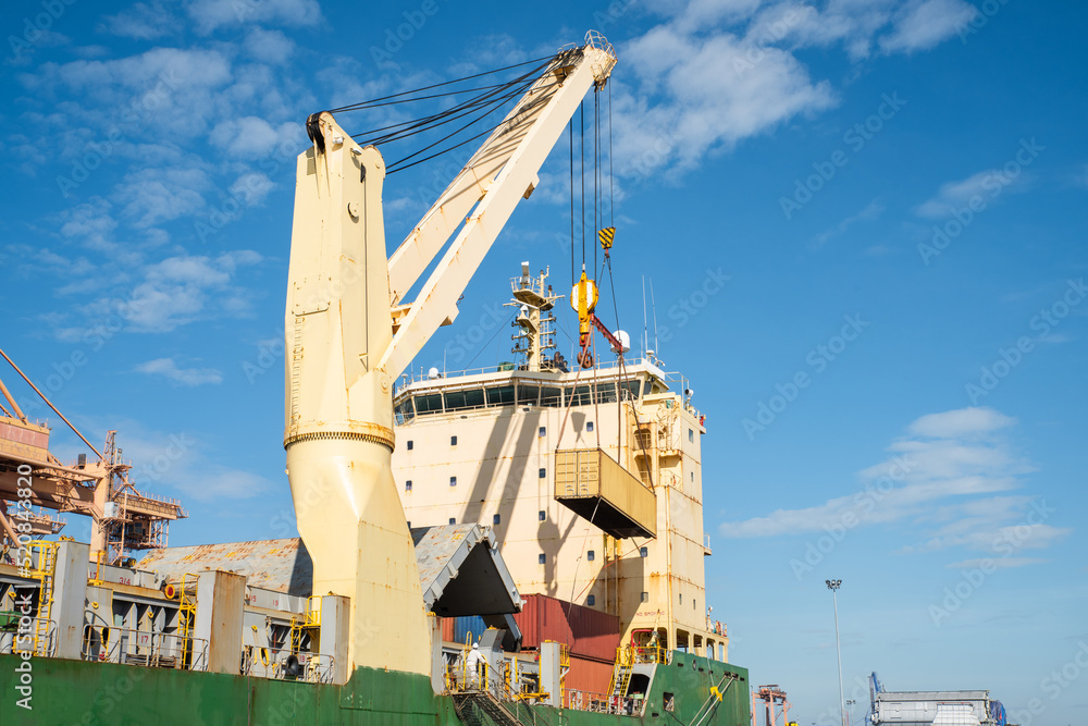 Cranes on a large cargo ship are loading containers Logistics and ...