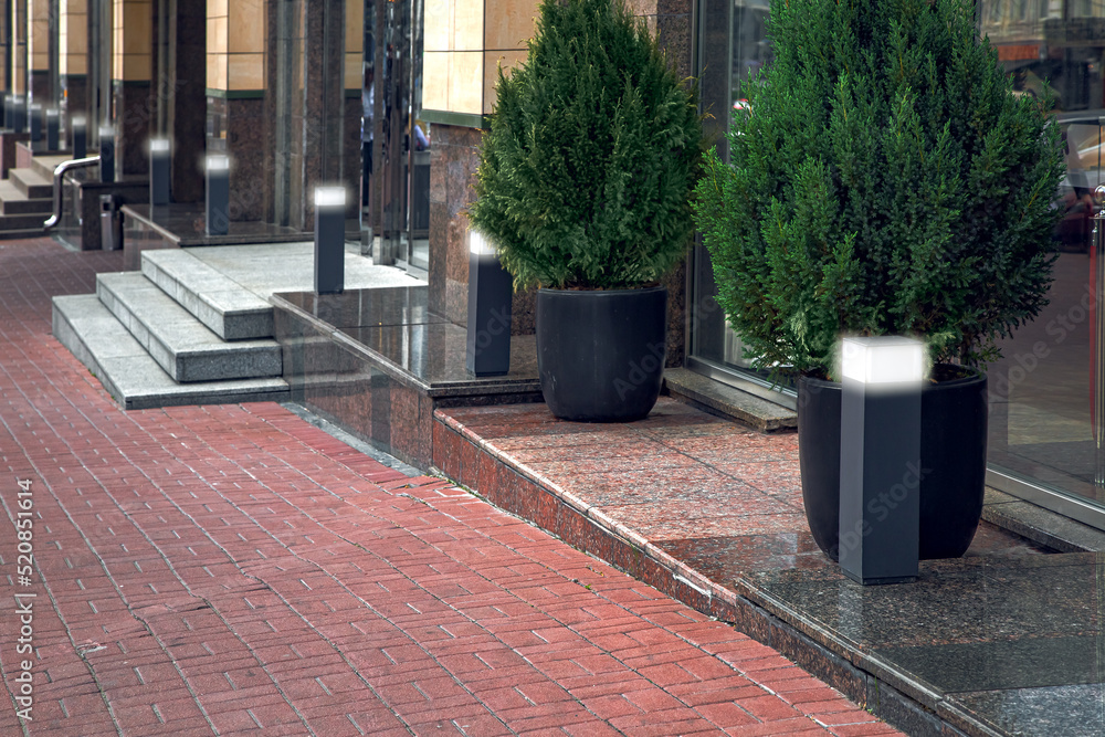 walkway made of stone tiles along building with thresholds and steps ...