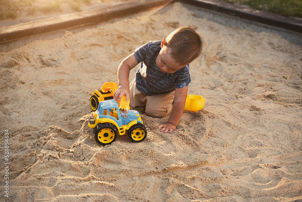Child playing with toys in sandbox. Little boy having fun on playground ...