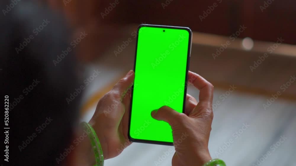 Closeup shot of Indian woman hand wearing bangles using mobile phone ...