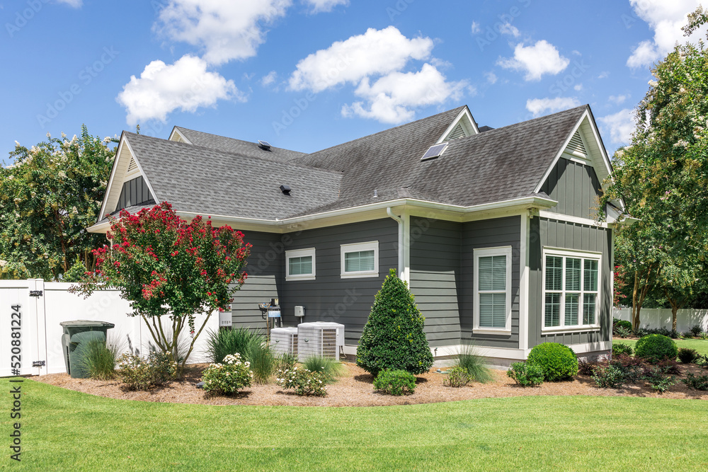 The side view of the backyard of a large gray craftsman new ...