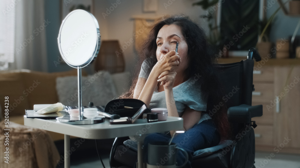 At home woman with spinal muscular atrophy in a wheelchair at the table ...