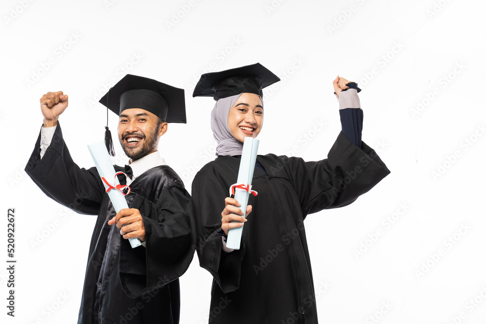 Happy graduates wearing togas holding certificate while celebrating ...