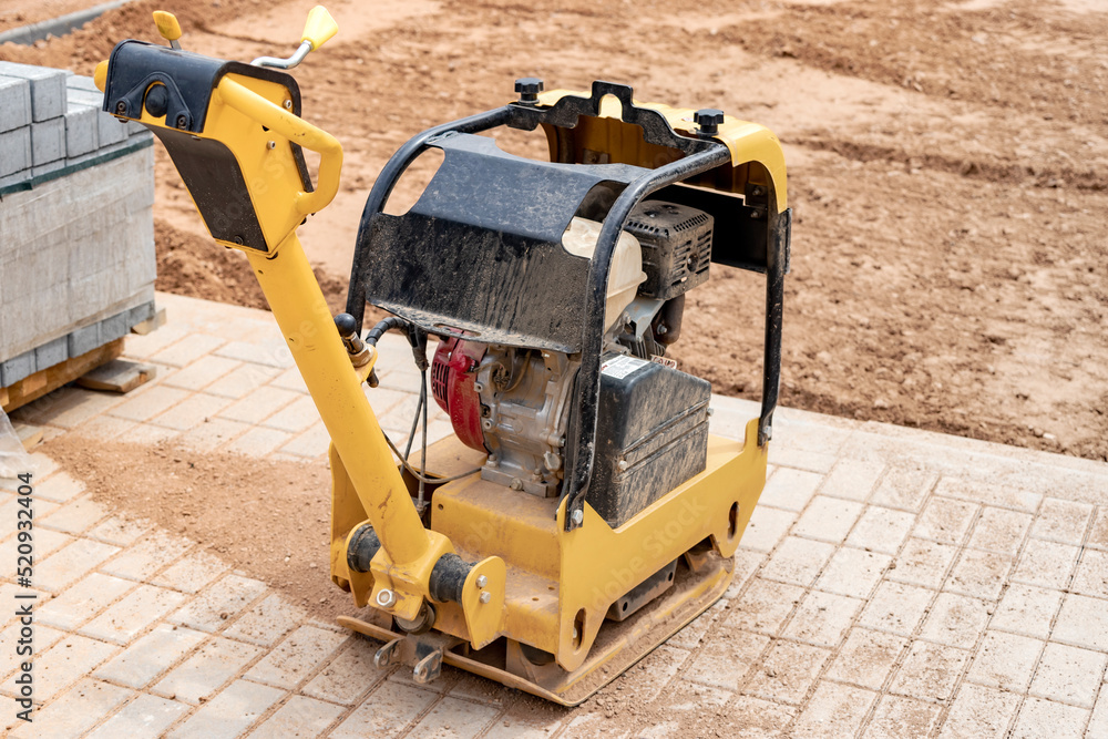Vibratory rammer with vibrating plate on a construction site ...