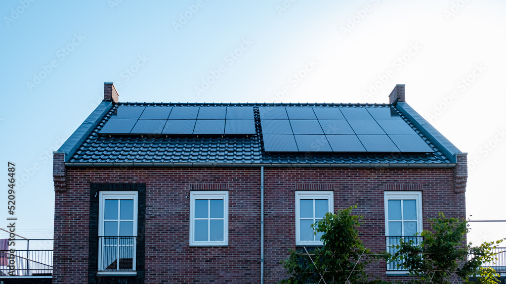Newly build houses with solar panels attached on the roof against a ...