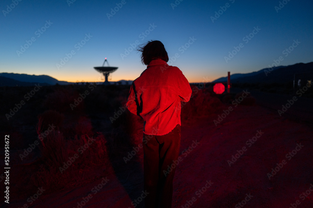 Curious stargazer, alien, and astronomy buff in moody red light ...