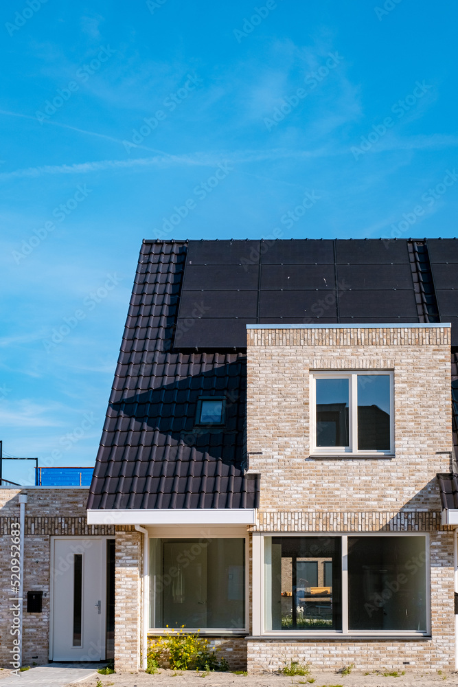 Newly build houses with solar panels attached on the roof against a ...