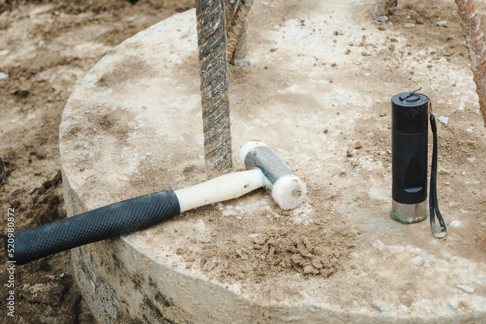 Seismic test on concrete pile. Engineer using the PIT Hand-Held Hammer ...