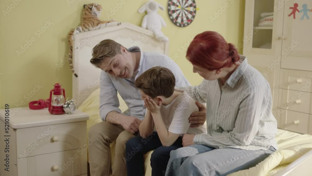 The little boy is in bed talking to his family about his problems at ...