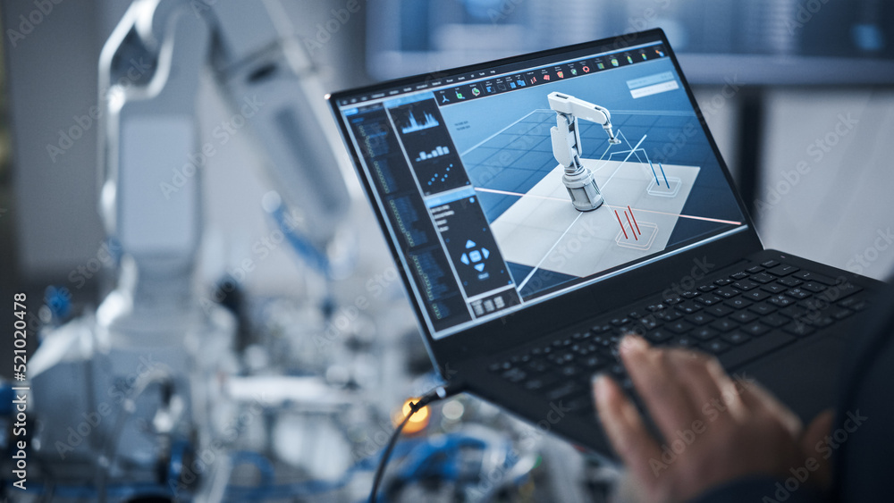 Black Female Engineer Using Laptop for Programming Robotic Arm At the ...