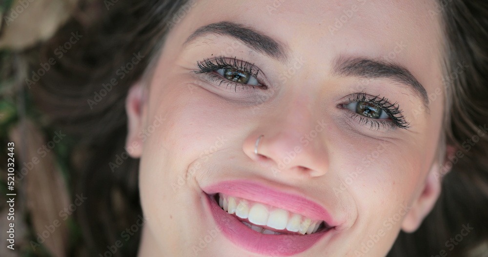 Pretty girl opens eye while laying down on grass at the park Woman with ...