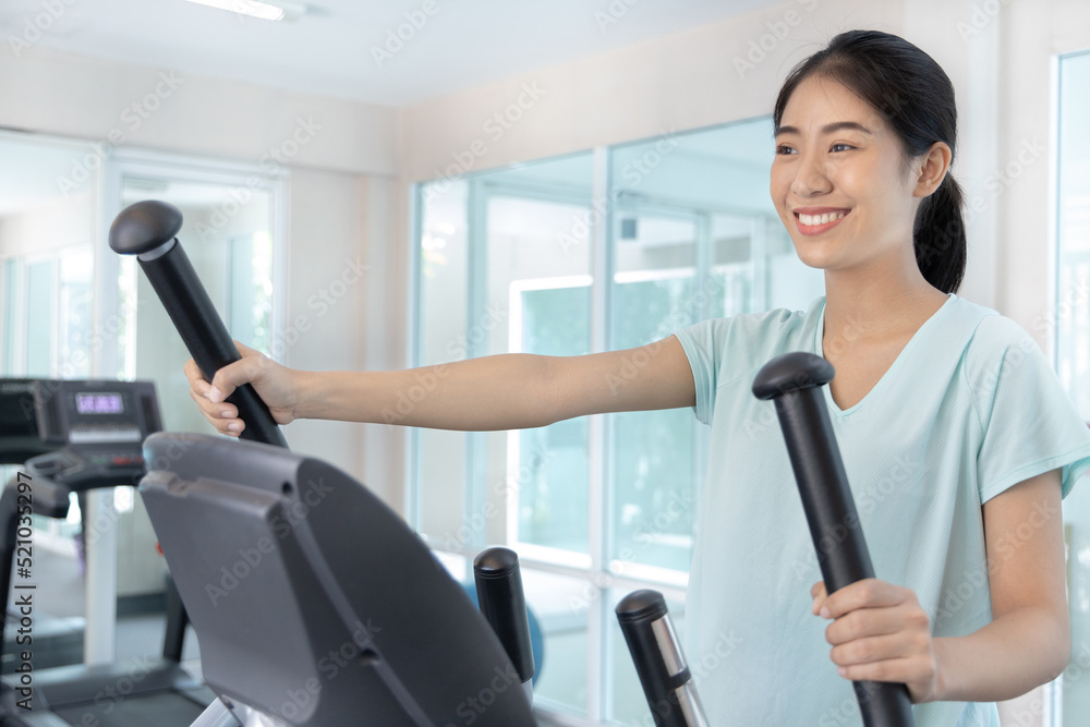 Beautiful and shapely Asian woman working out in the gym, Play exercise ...