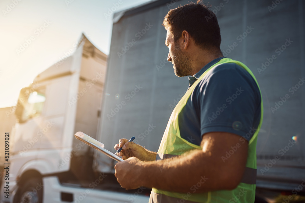 Cargo dispatcher checking shipment list on truck parking lot. Stock ...