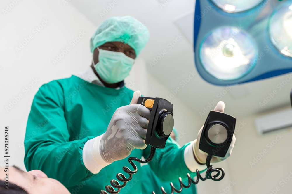 Zdjęcie Stock: The doctor is giving a defibrillators to save the ...