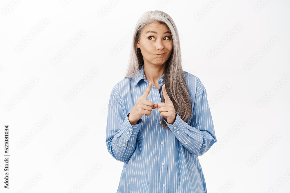 Image of cute asian woman looking innocent and shy, standing over white ...