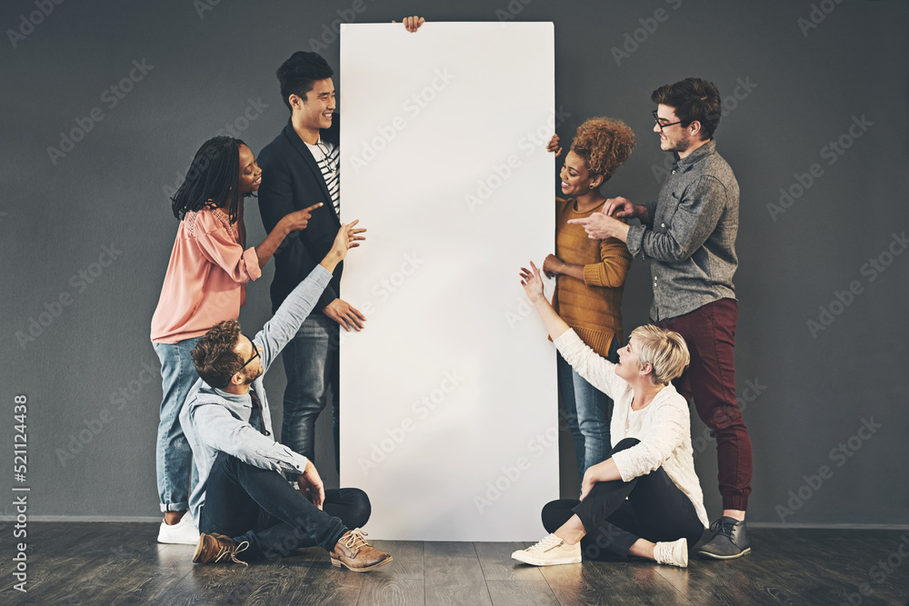 A diverse group of people holding a blank white board or poster and ...