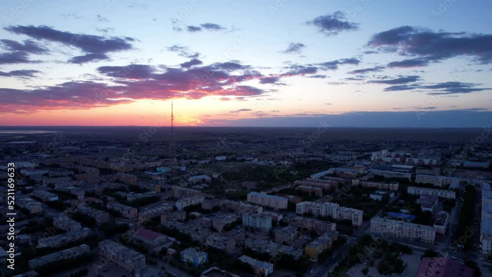 Pink sunset over a small town. Top view from a drone. The sun is ...