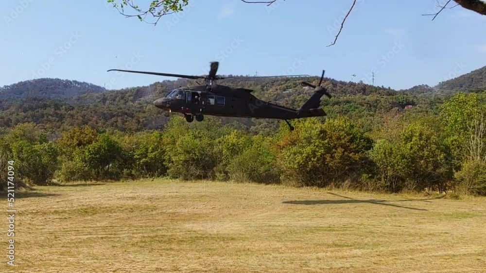 Military Black Hawk taking off grass field and flying overhead ...