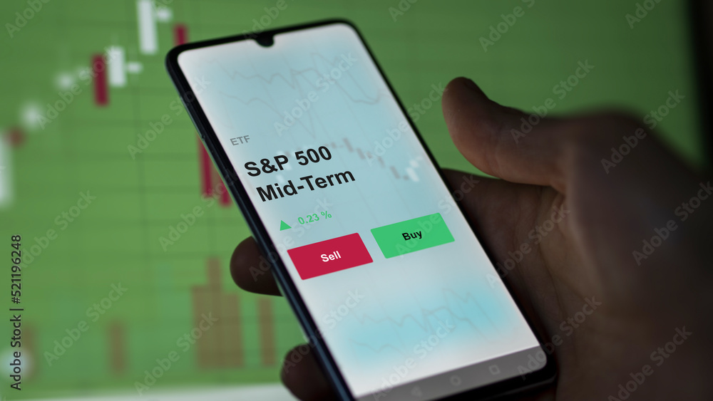 An investor's analyzing the s&p 500 mid-term etf fund on a screen. A phone shows the prices of S ...