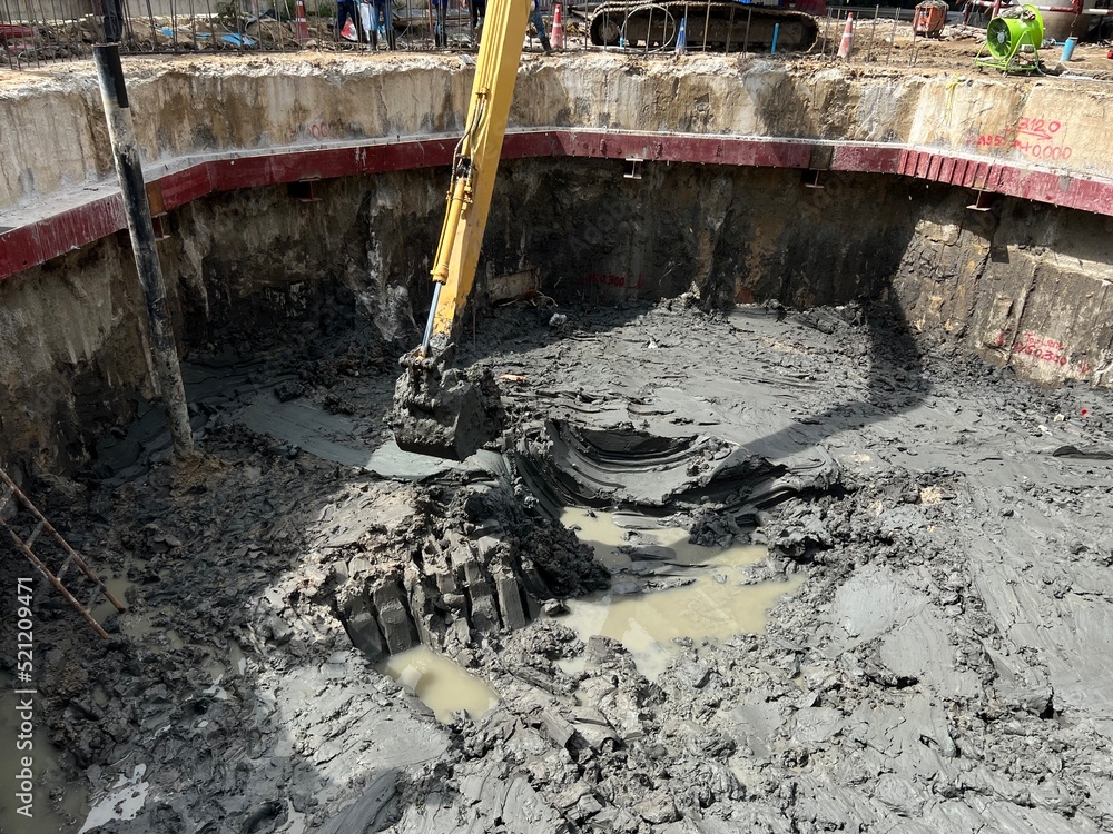 The soil in the black pit, the yellow excavator is digging out the soil ...